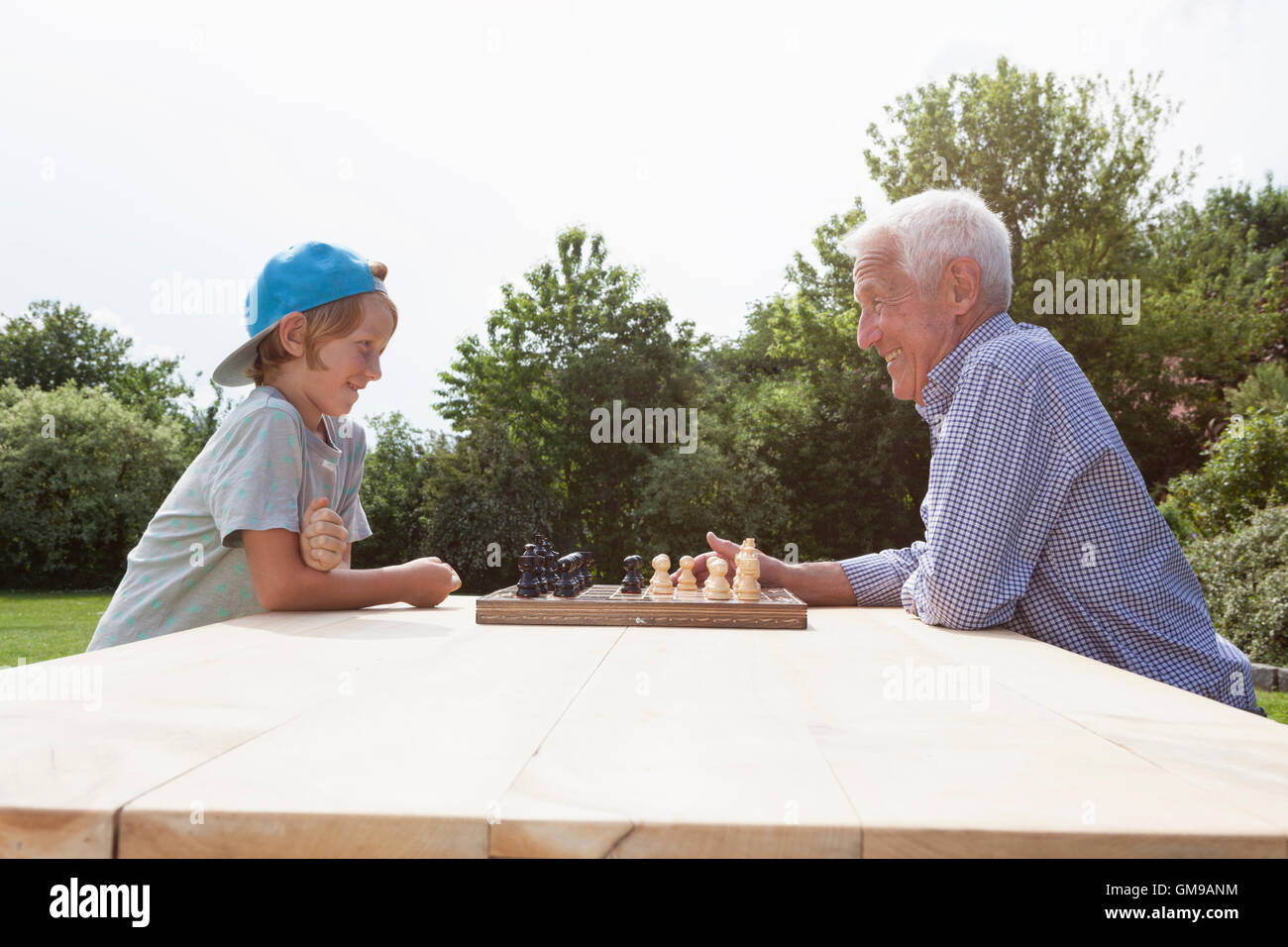 Grandfather and grandson playing chess in garden Stock Photo - Alamy