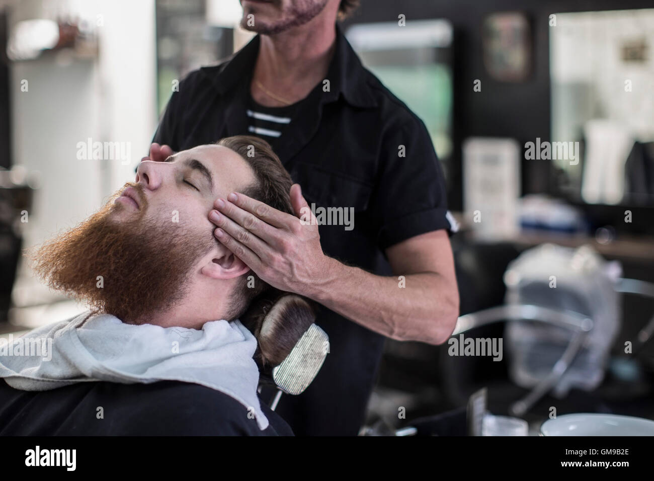 Barber measures on customers head before haircut at the barbershop ...