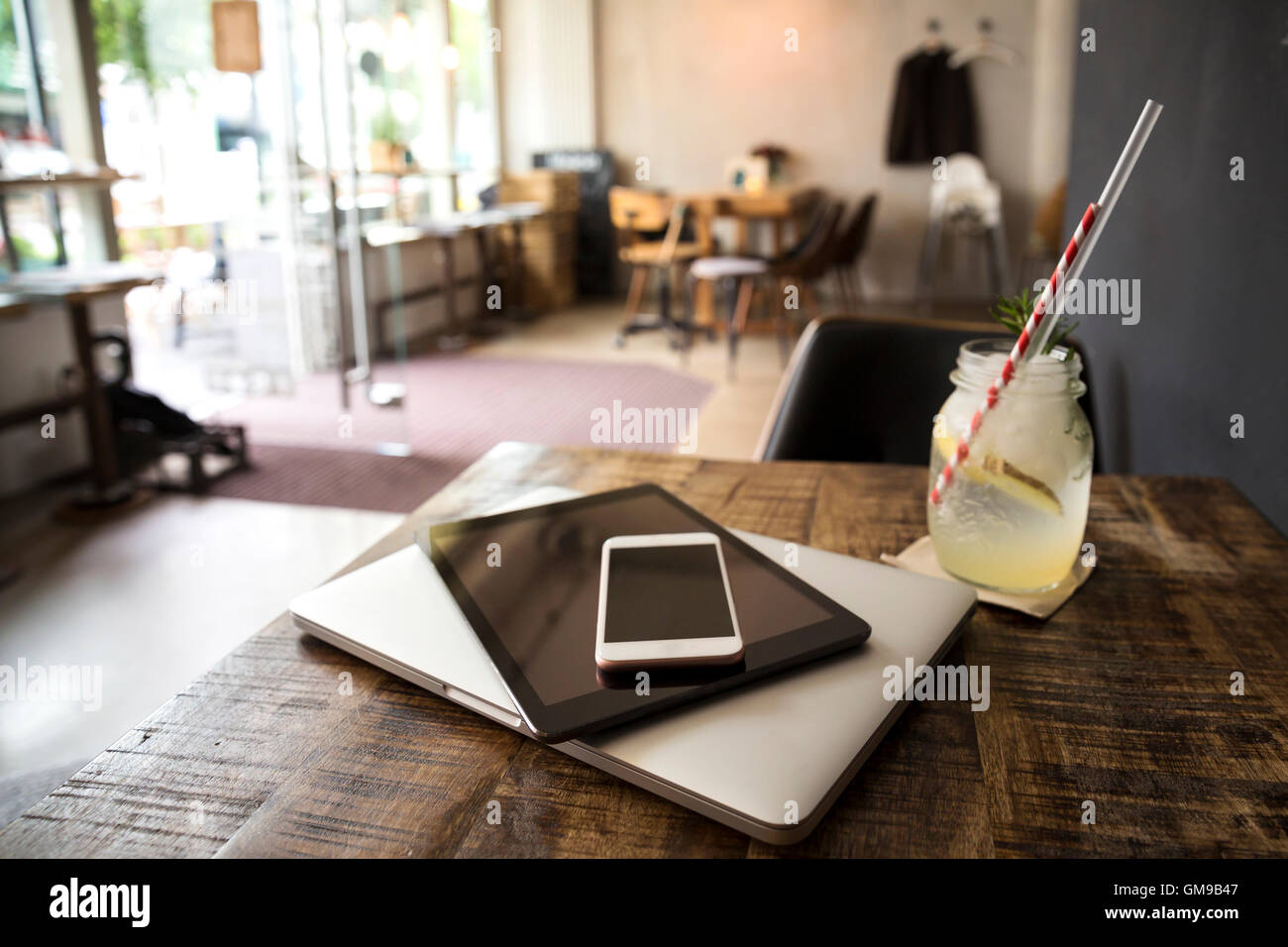 Mobile devices on table in a cafe Stock Photo - Alamy