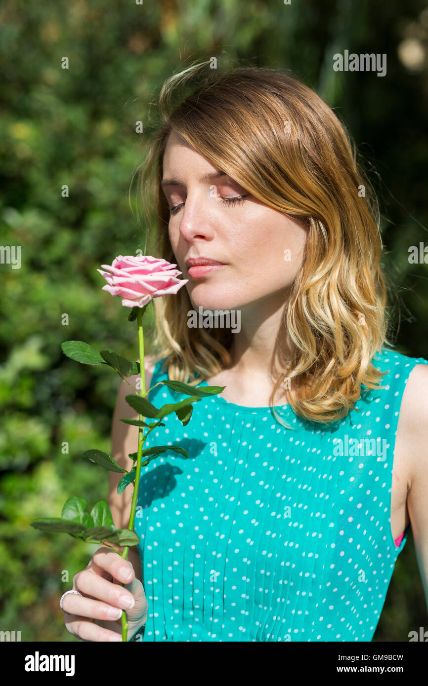 Young woman smelling on pink hi-res stock photography and images - Alamy