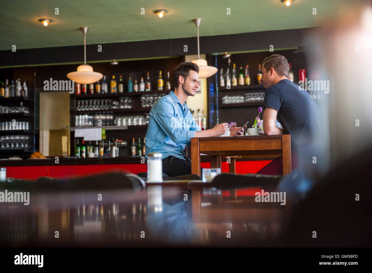 To men socializing in a cafe Stock Photo - Alamy