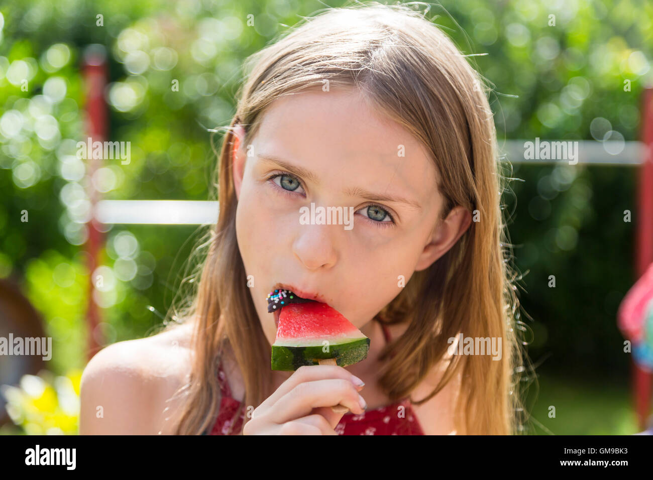 Portrait of girl eating iced watermelon lolly Stock Photo - Alamy