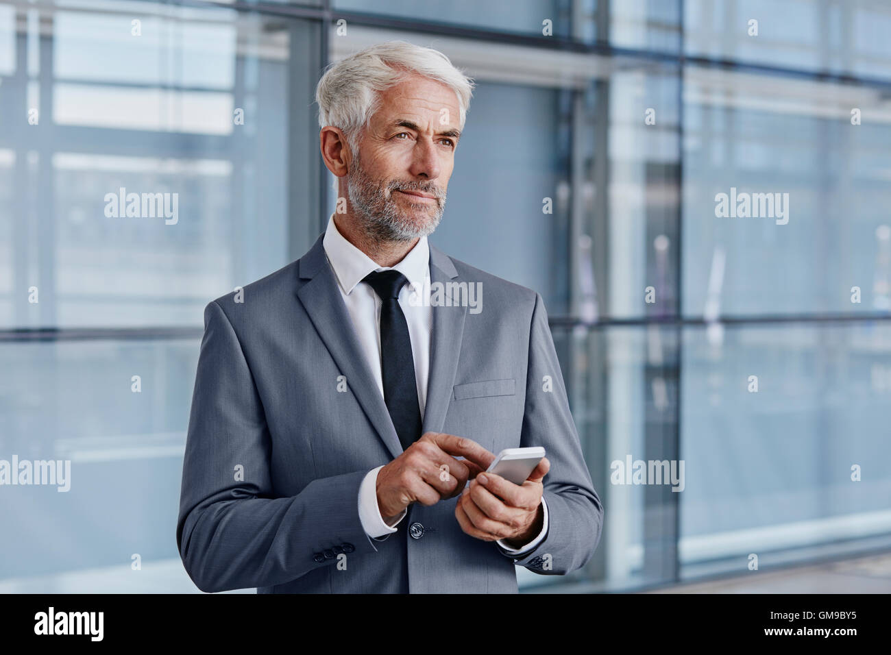 Confident businessman using cell phone Stock Photo - Alamy