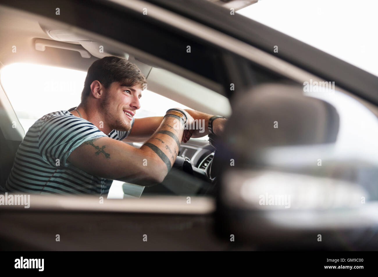 Smiling young man in car Stock Photo - Alamy
