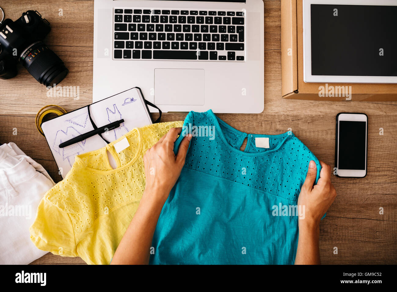 Woman holding garment at desk Stock Photo - Alamy
