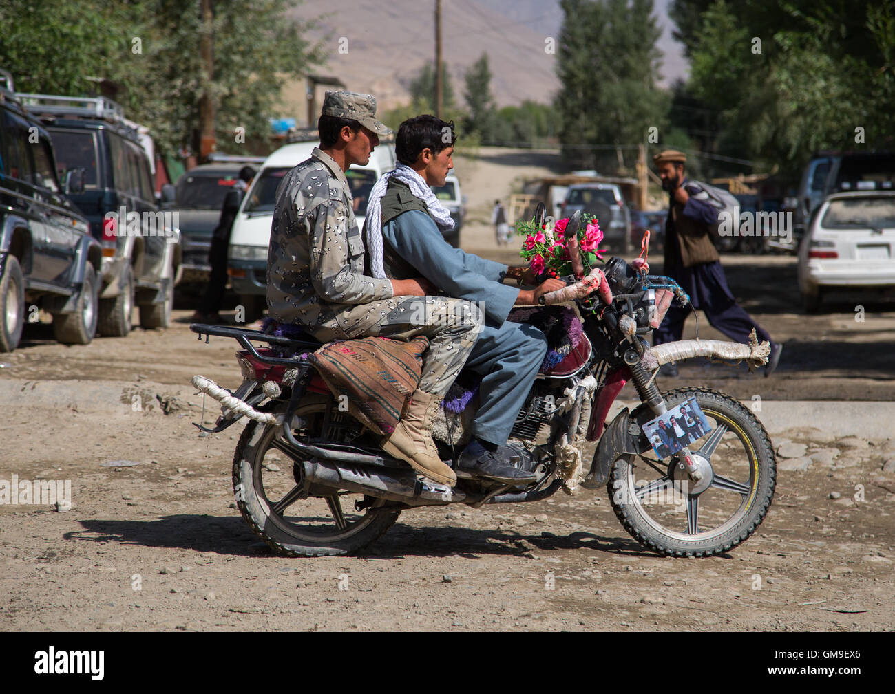 Men riding a motorcycle in the streets of the market, Badakhshan ...