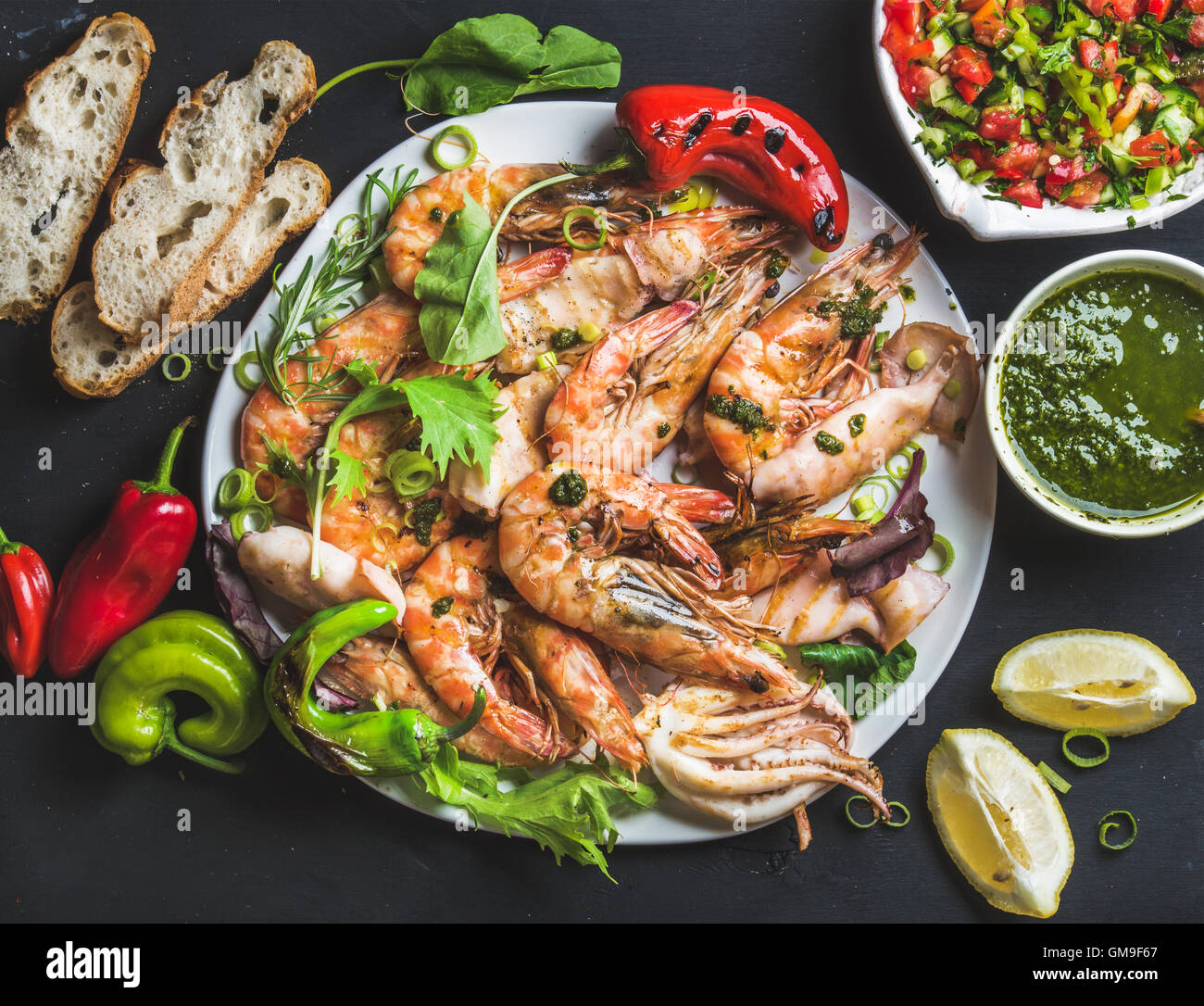 Plate of roasted tiger prawns and octopus pieces with fresh leek, salad ...