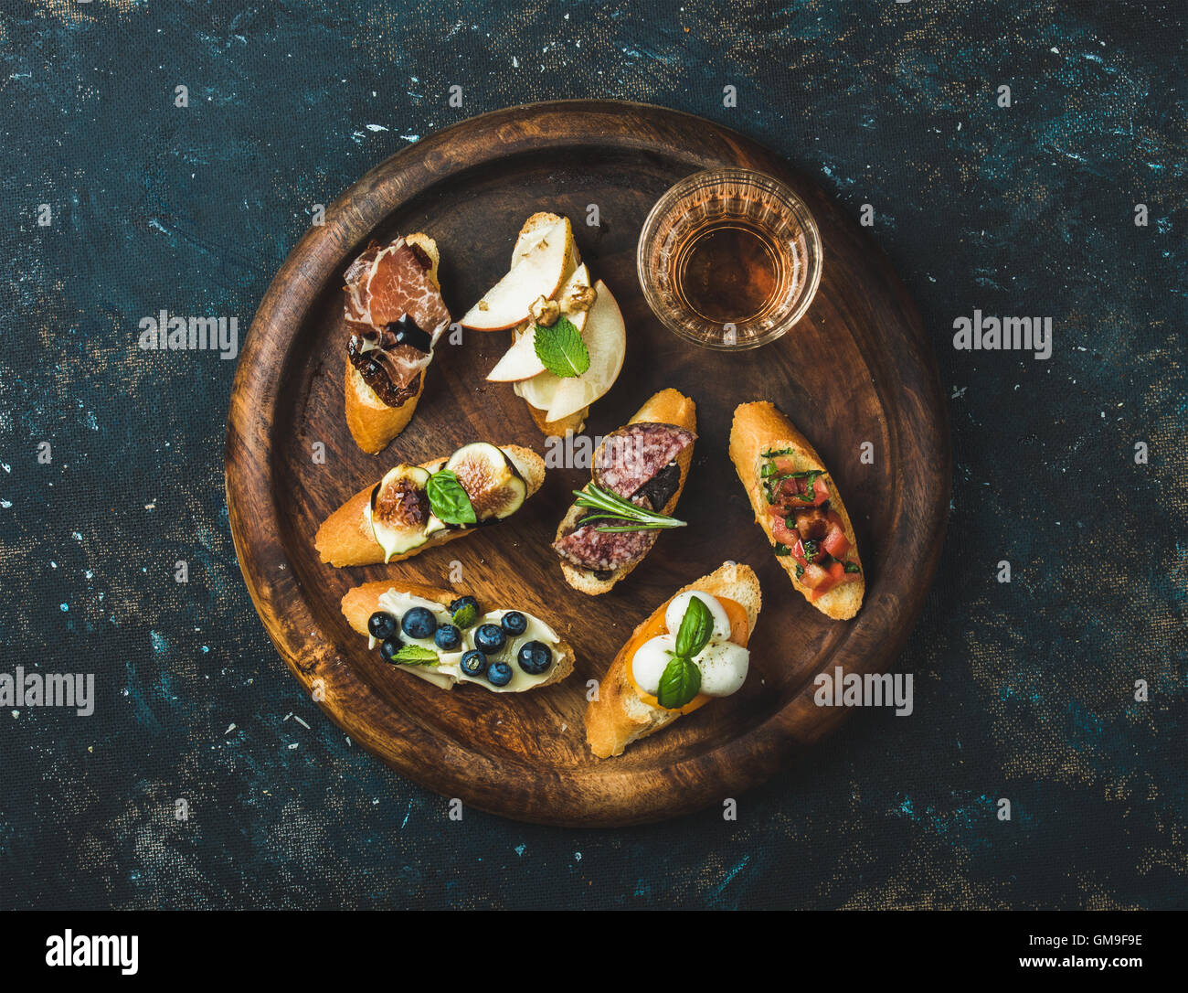 Italian crostini and glass of wine on round serving tray Stock Photo ...