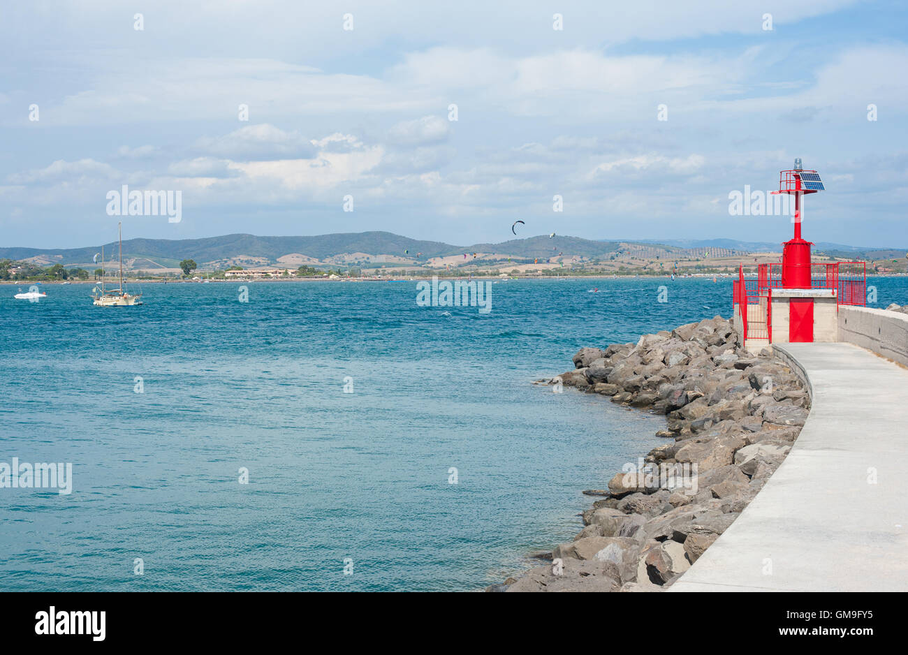 Red marine beacon light with solar panels energy on harbor dock, sea ...