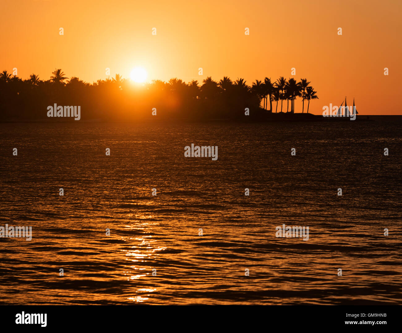Sunset over island Stock Photo - Alamy