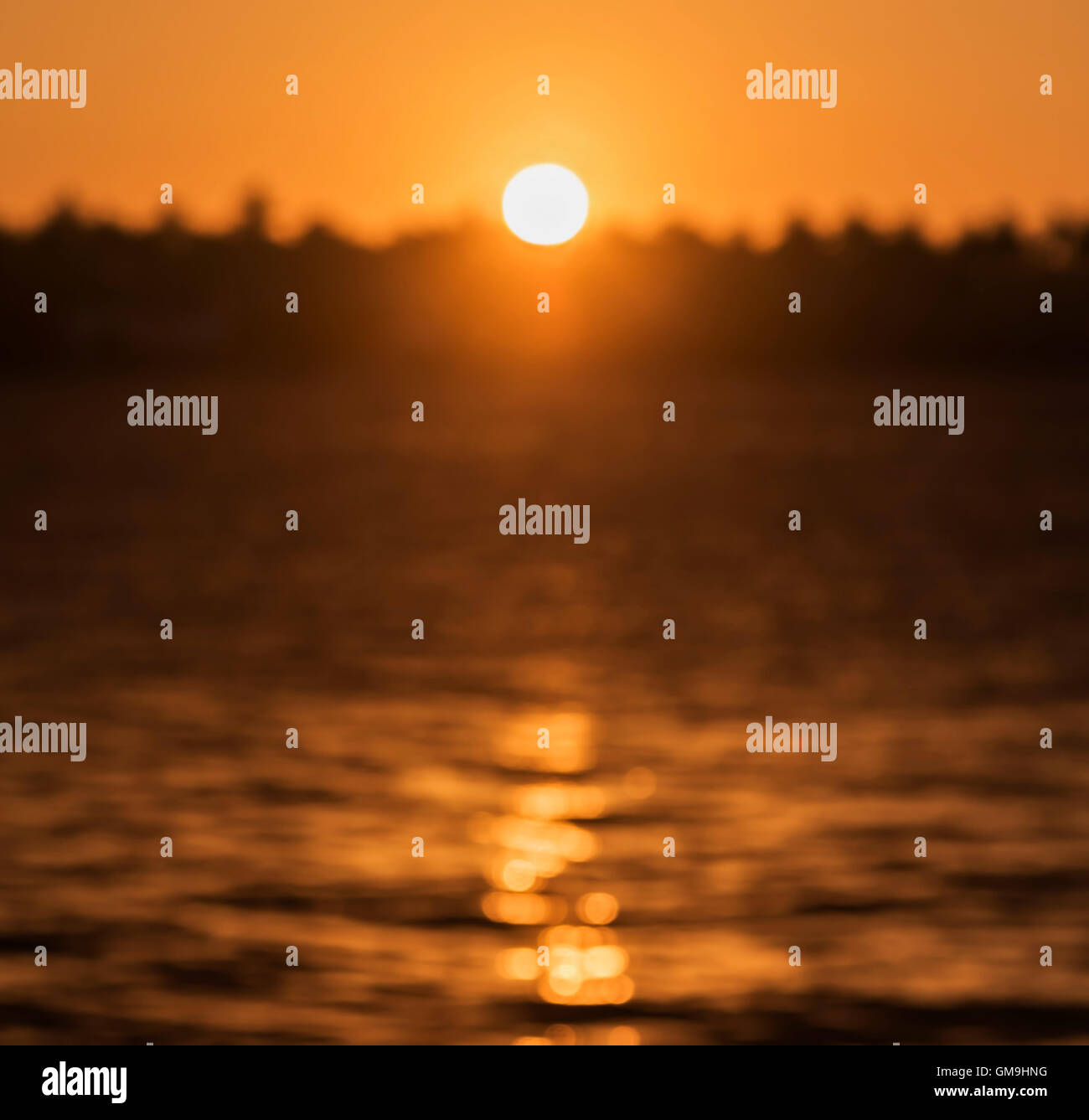 Sunset over island Stock Photo - Alamy