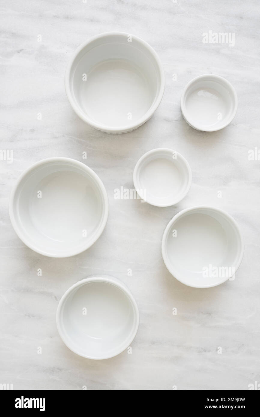 Overhead view of empty white ceramic bowls on marble table Stock Photo ...