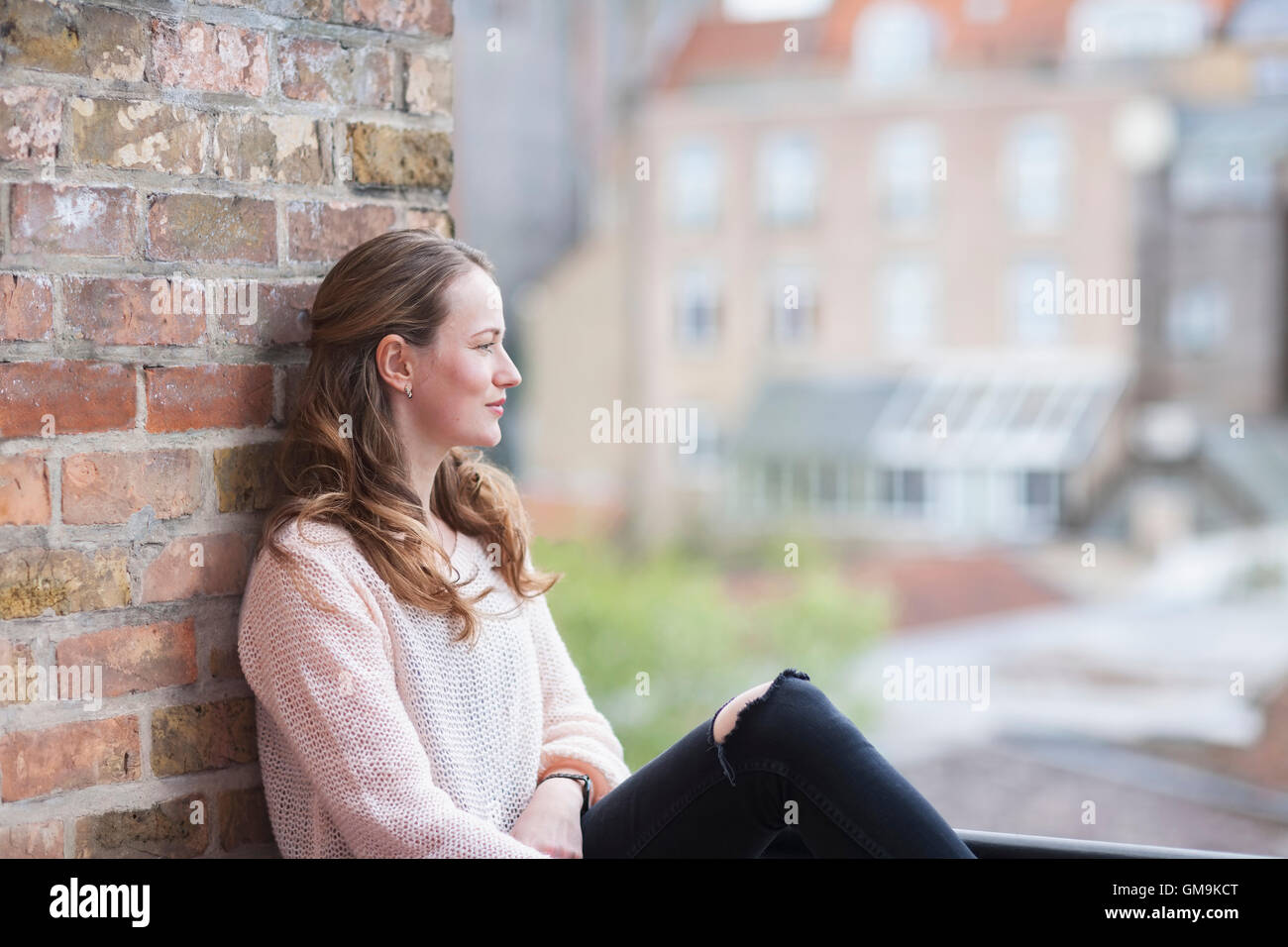 Woman Sitting Against Wall