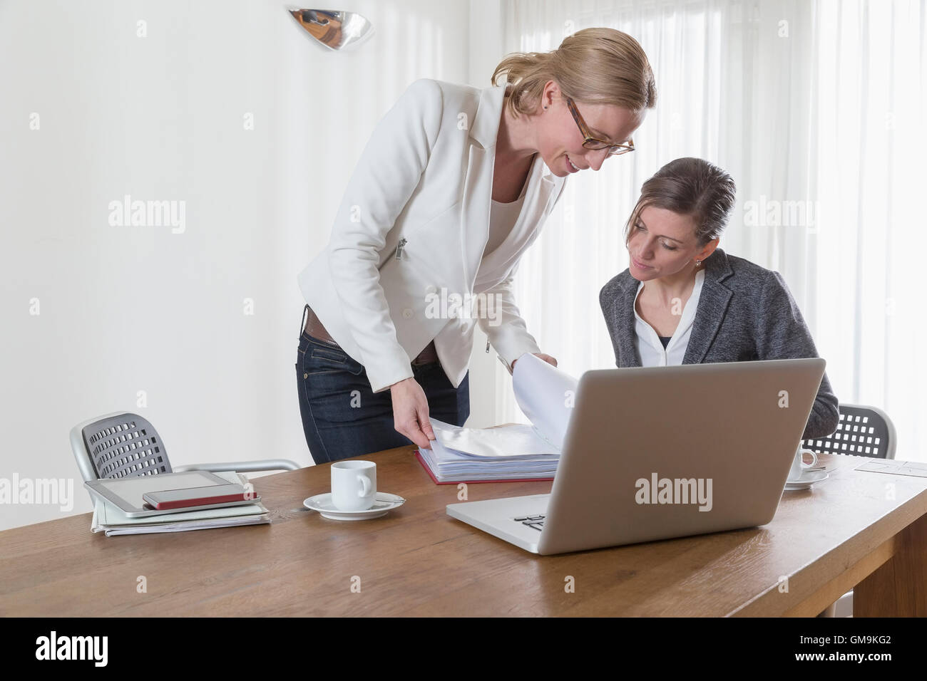 Businesswomen looking at documents at office Stock Photo - Alamy