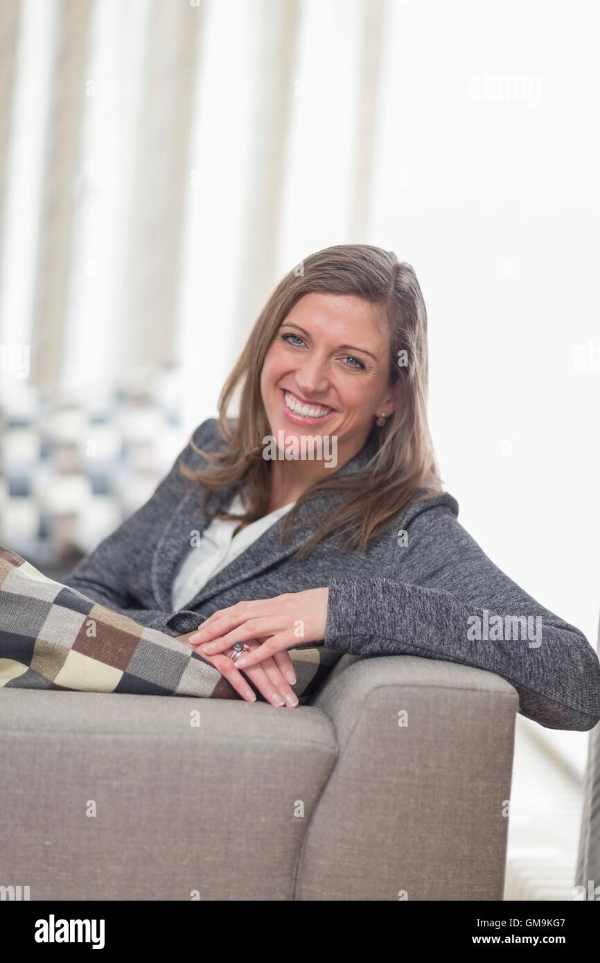 Woman smiling indoors on sofa hi-res stock photography and images - Alamy