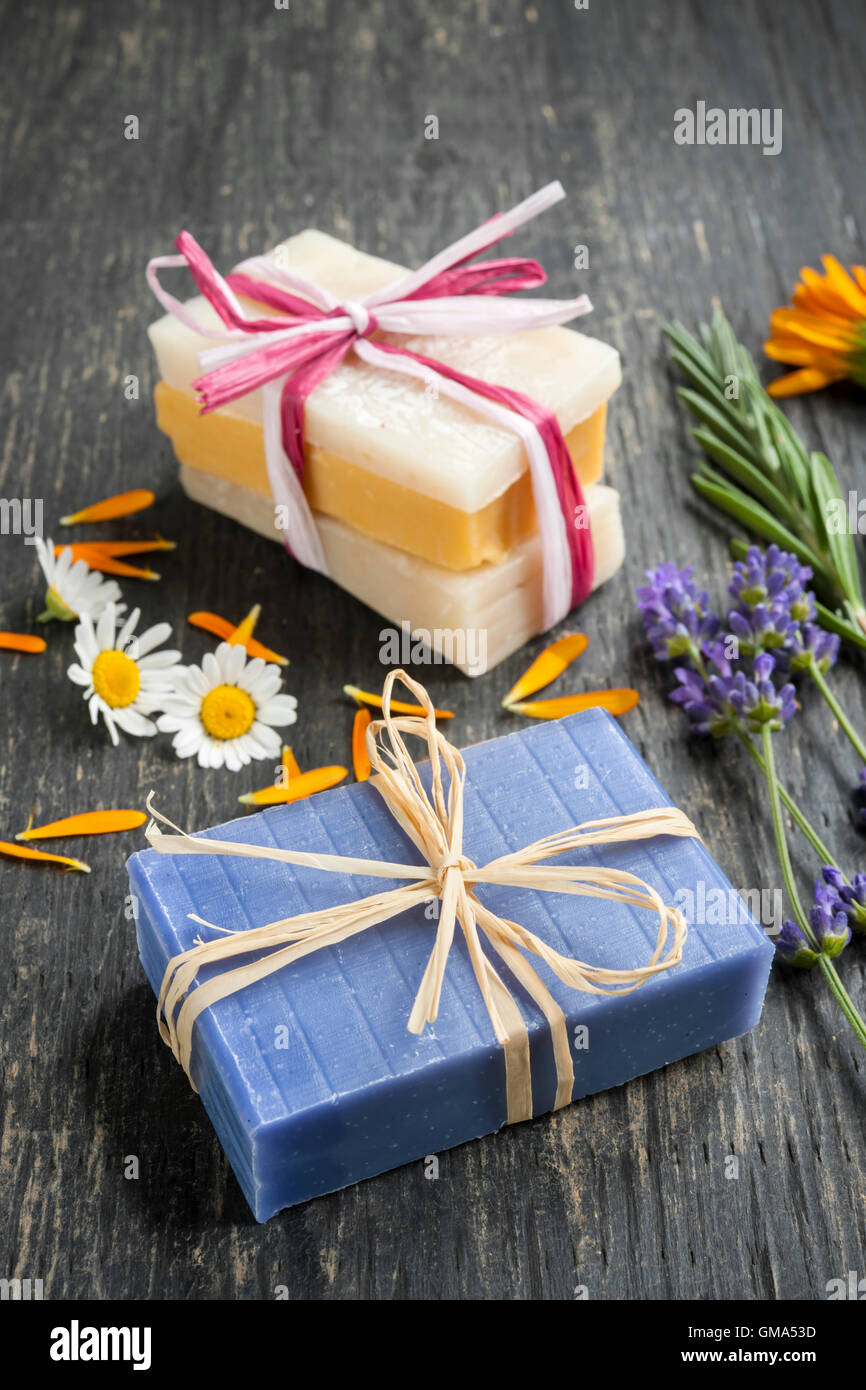 Colorful handmade soaps with fresh herbs on rustic wooden background ...