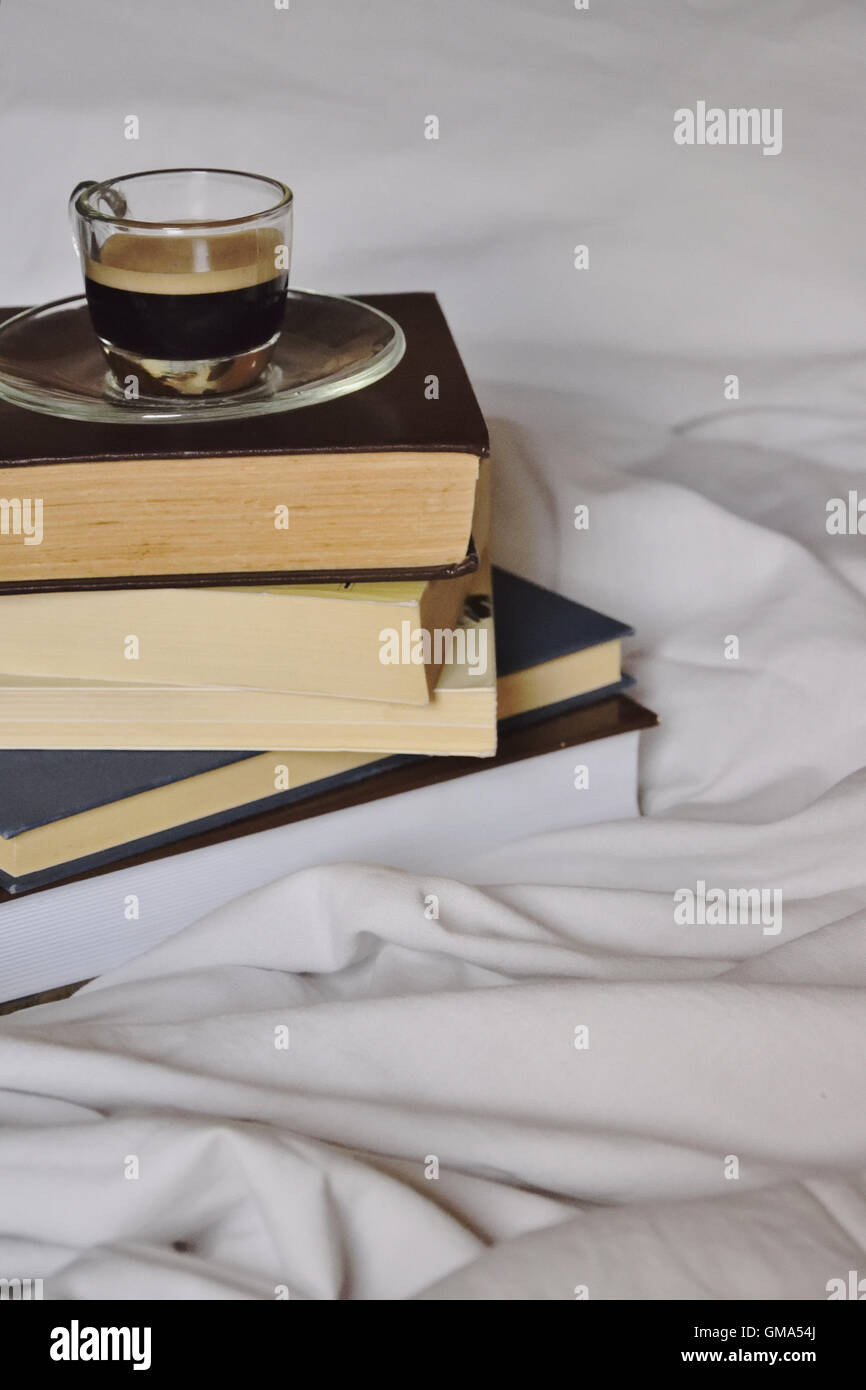 Stack of books with cup of coffee in bed Stock Photo - Alamy