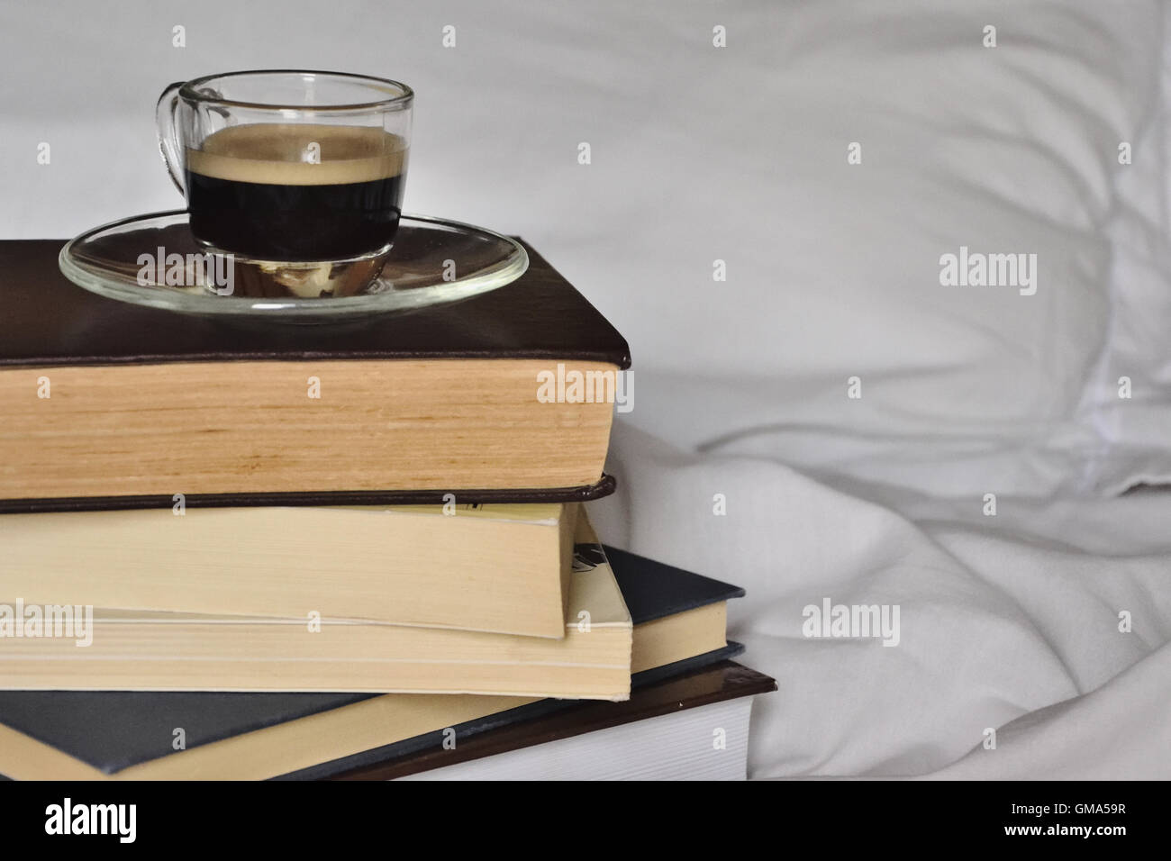 Stack of books with cup of coffee in bed Stock Photo - Alamy