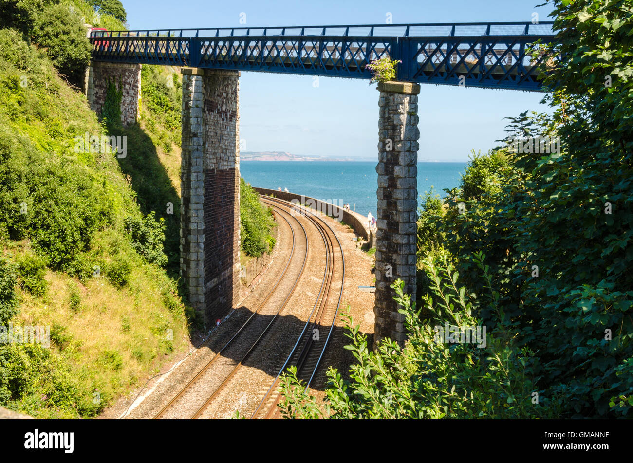 A bridge passes over the railway line which winds round the seafront at ...