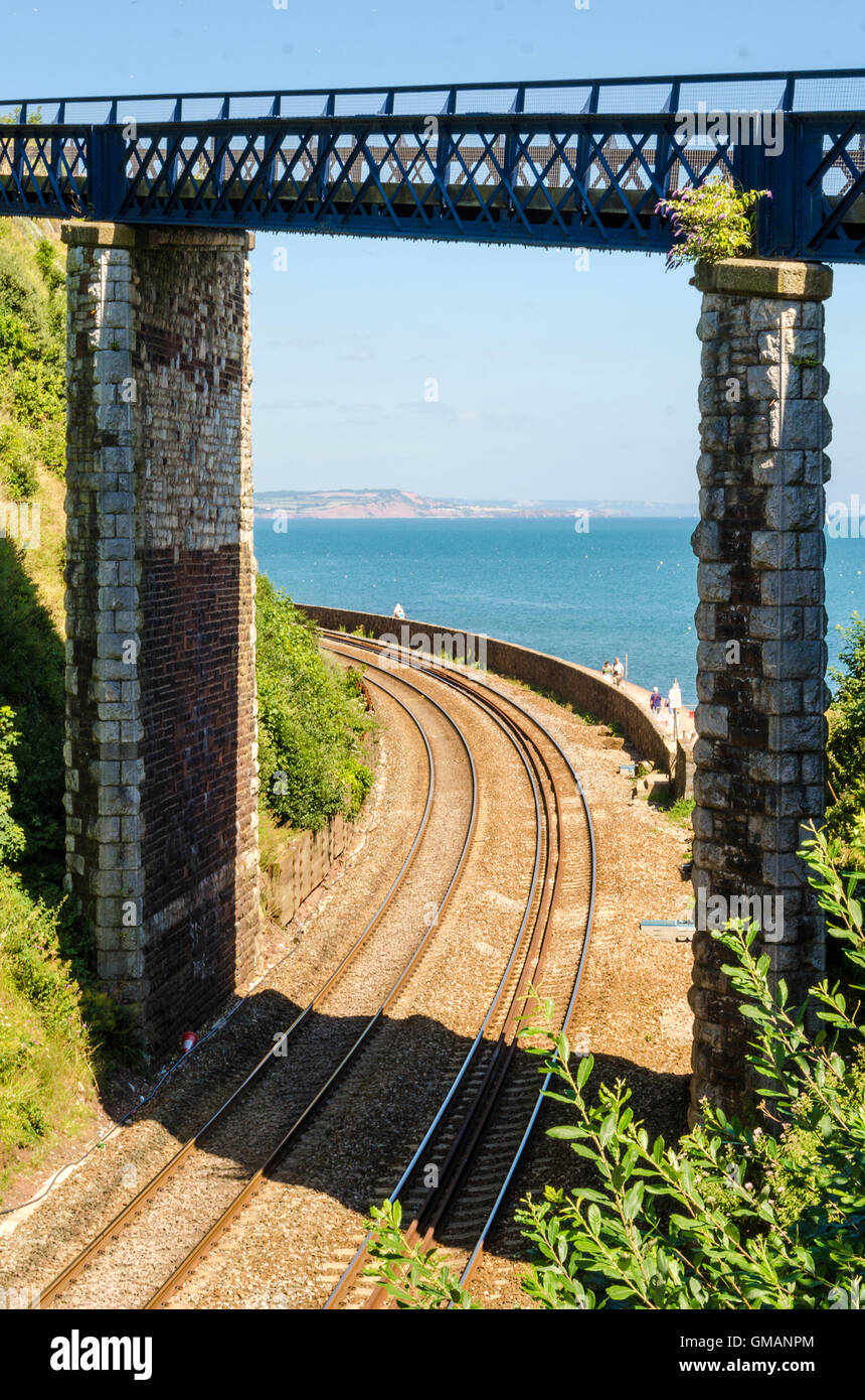A bridge passes over the railway line which winds round the seafront at ...