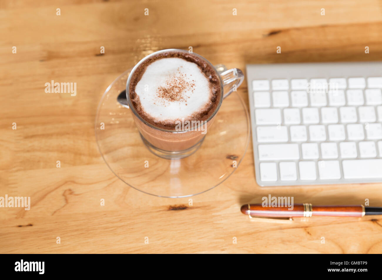hot cocoa chocolate drink with computer keyboard and pen on wooden desk ...