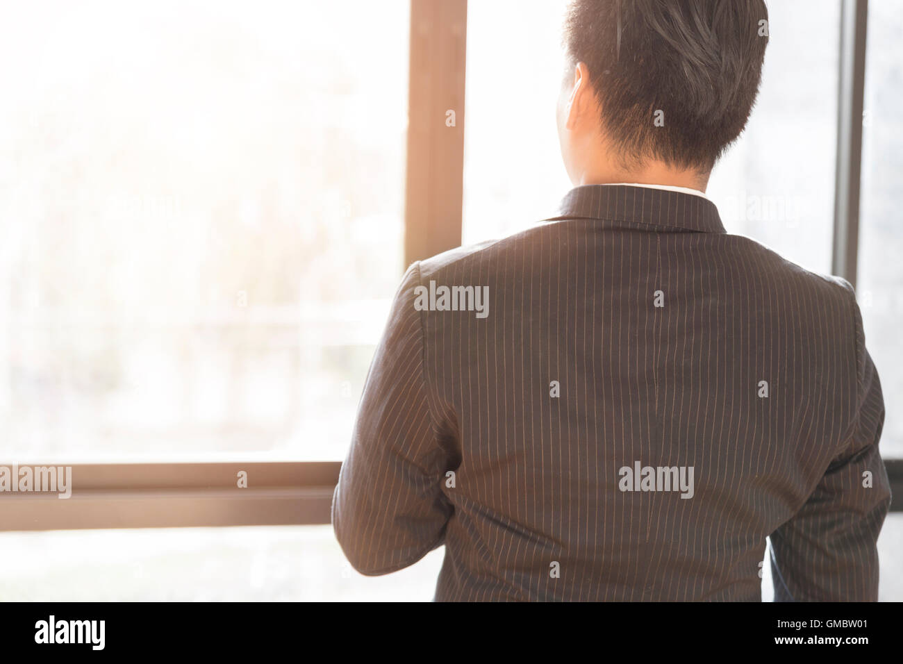 back of businessman in suit looking out through office window Stock ...
