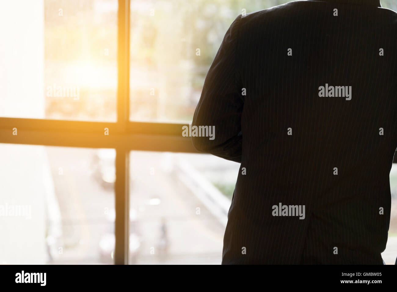 back of businessman in suit looking out through office window Stock ...