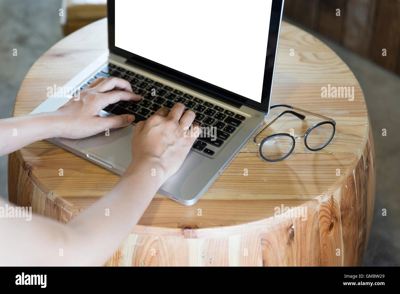 woman's hand on laptop computer notebook with eyeglasses on wooden desk ...