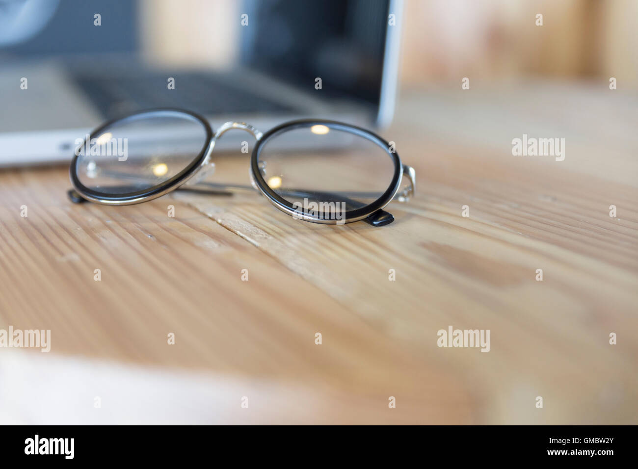 eyeglasses with laptop computer notebook on wooden desk Stock Photo - Alamy