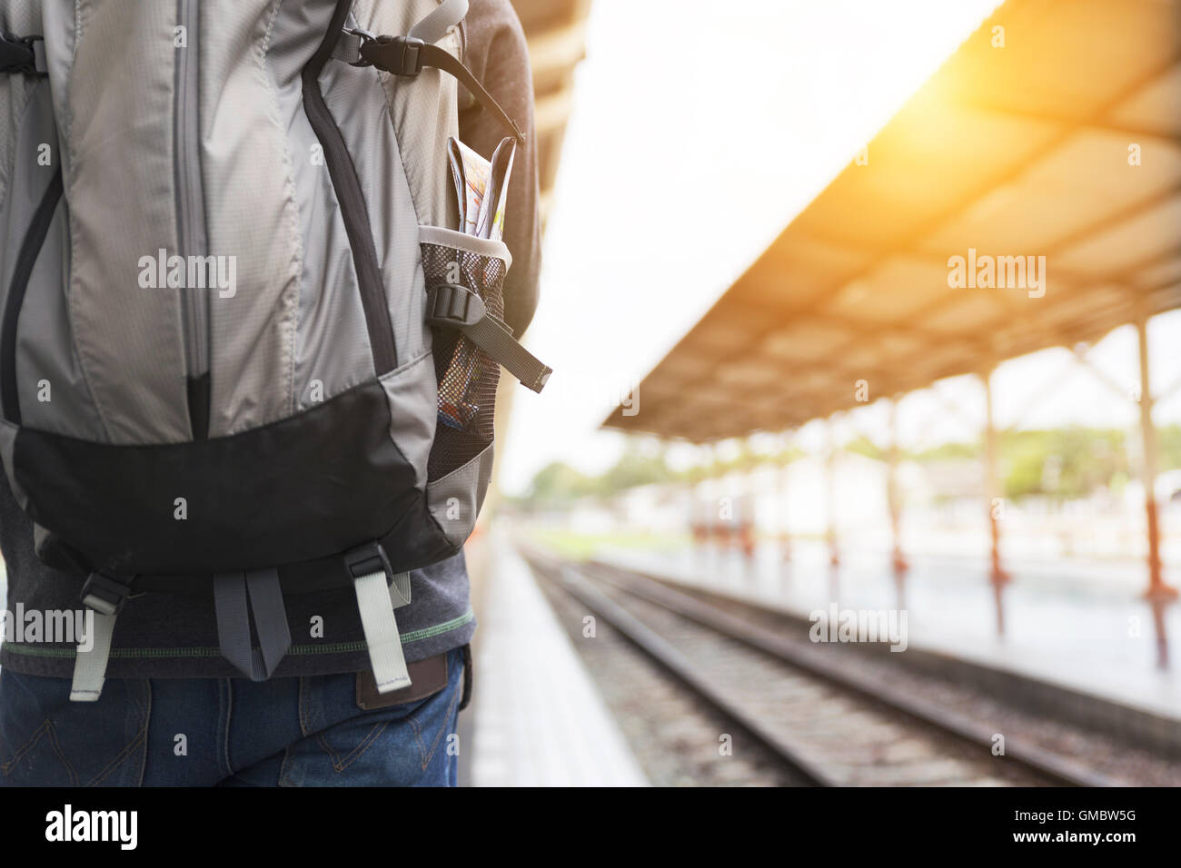 young man with backpack standing on platform at train station - travel ...