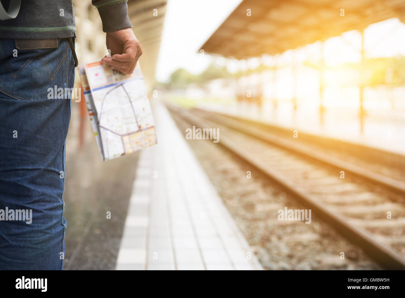 young man holding map standing on platform at train station - travel ...