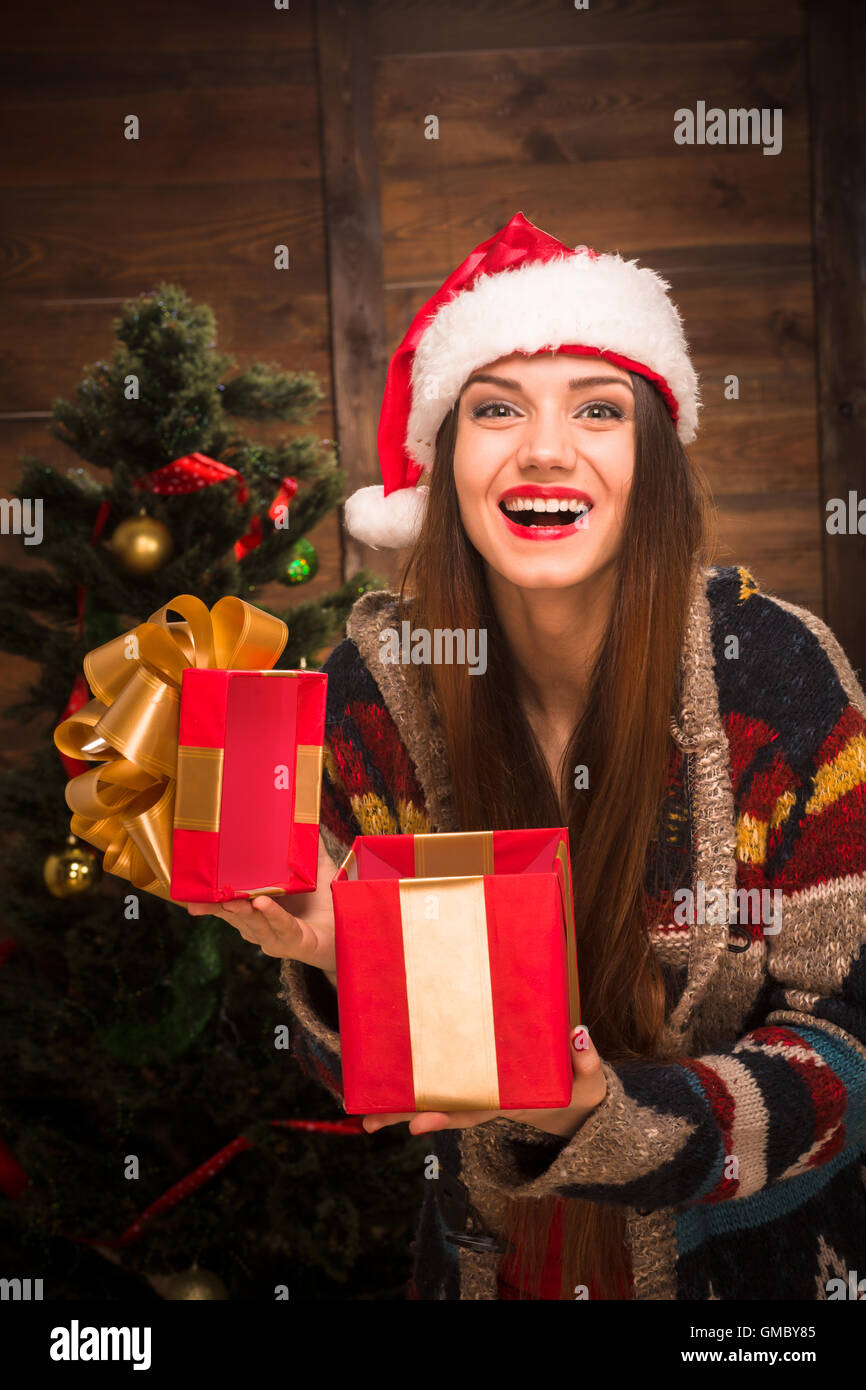 Beautiful girl opening a present near New Year tree Stock Photo - Alamy