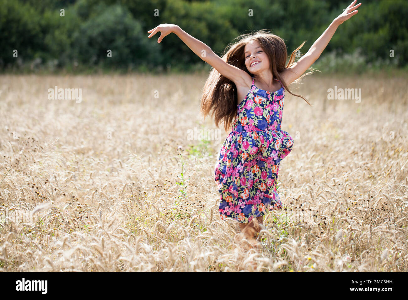 Happy little girl running in summer field Stock Photo - Alamy