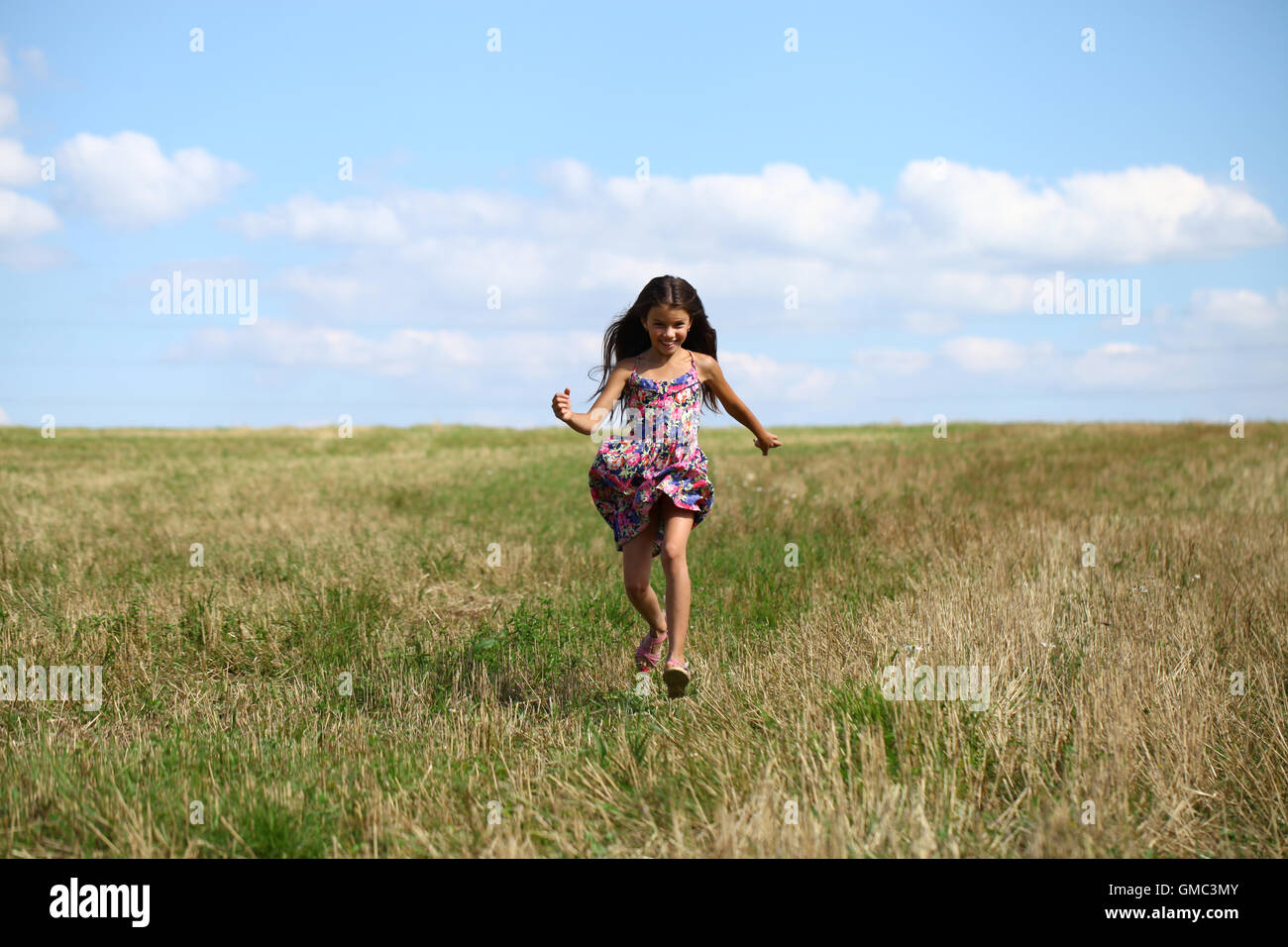 Happy little girl running in summer field Stock Photo - Alamy