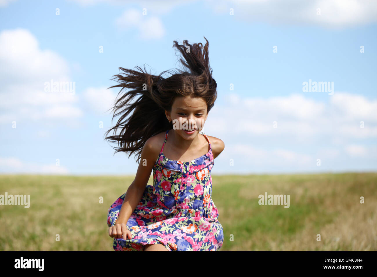 Happy little girl running in summer field Stock Photo - Alamy
