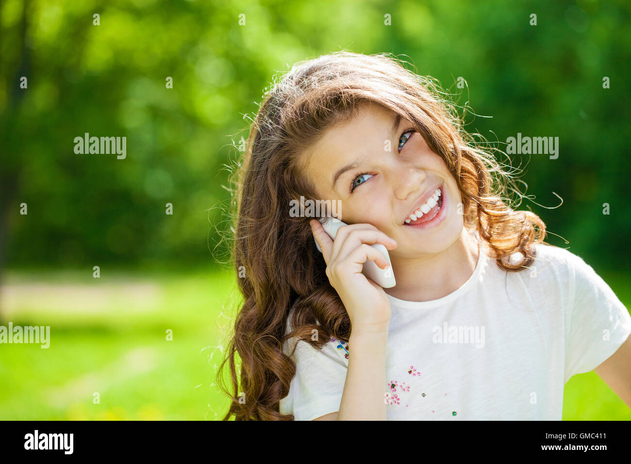 Beautiful little girl calling by mobile phone on the background of ...