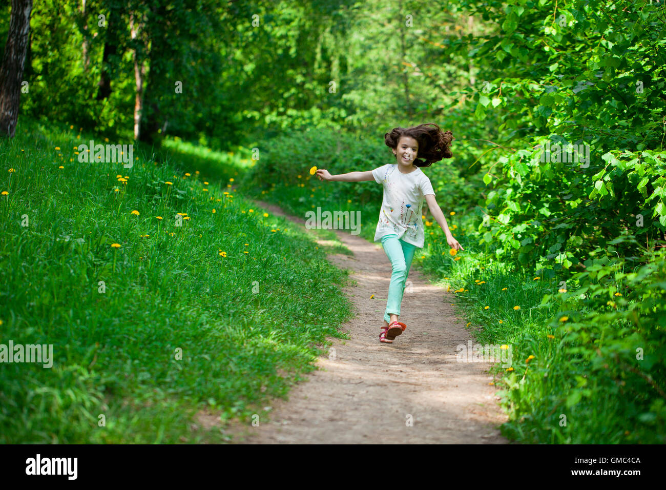 Happy little girl running in summer park Stock Photo - Alamy