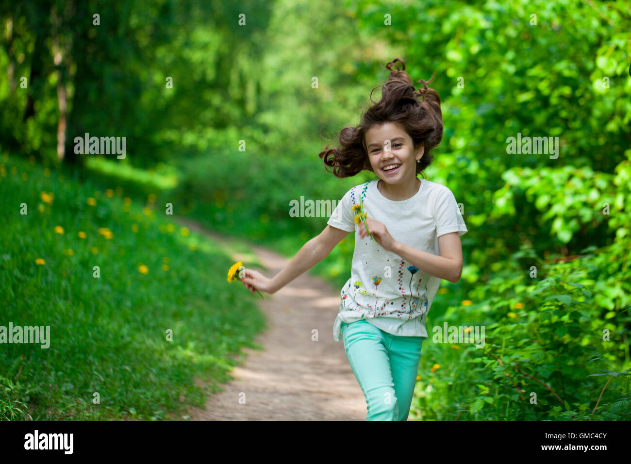 Happy little girl running in summer park Stock Photo - Alamy