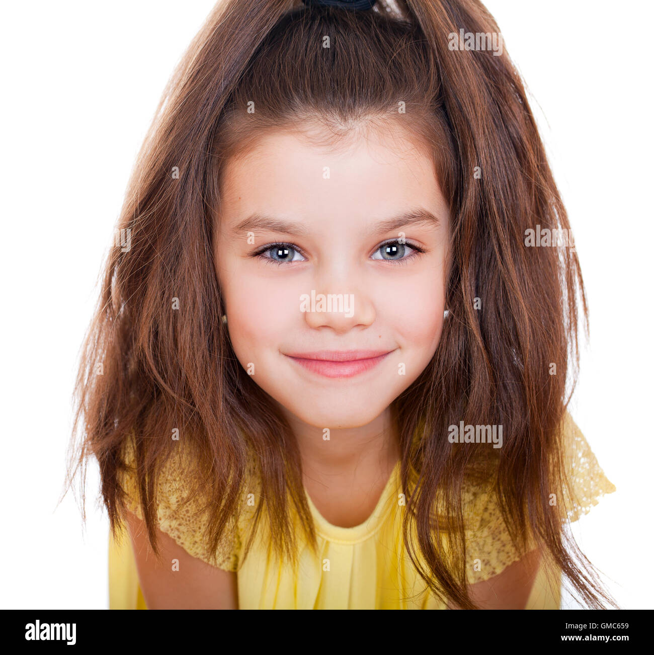 Portrait of a charming little girl smiling at camera, isolated on white ...