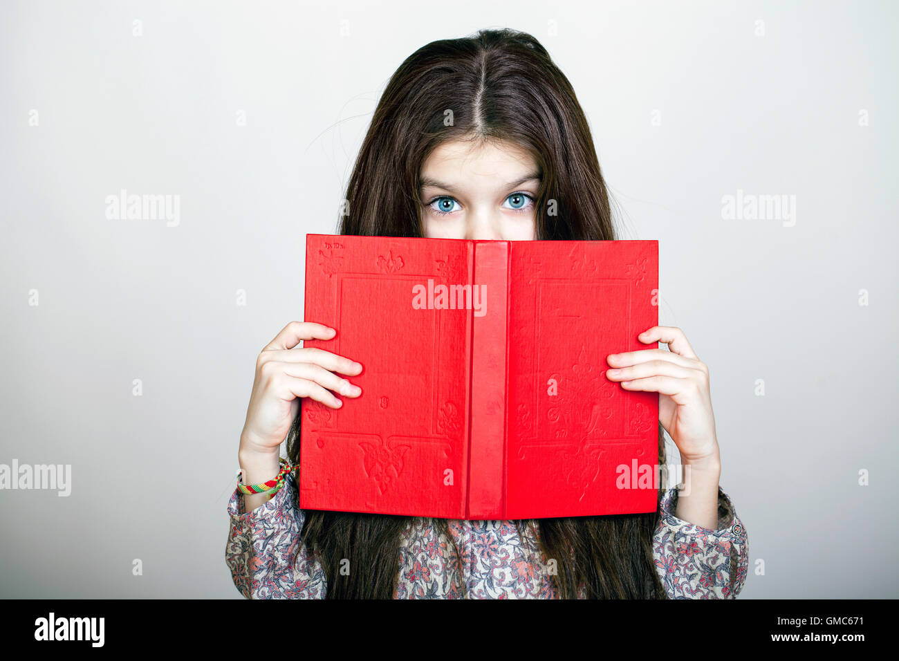 Little girl holding red book, studio on white background Stock Photo ...