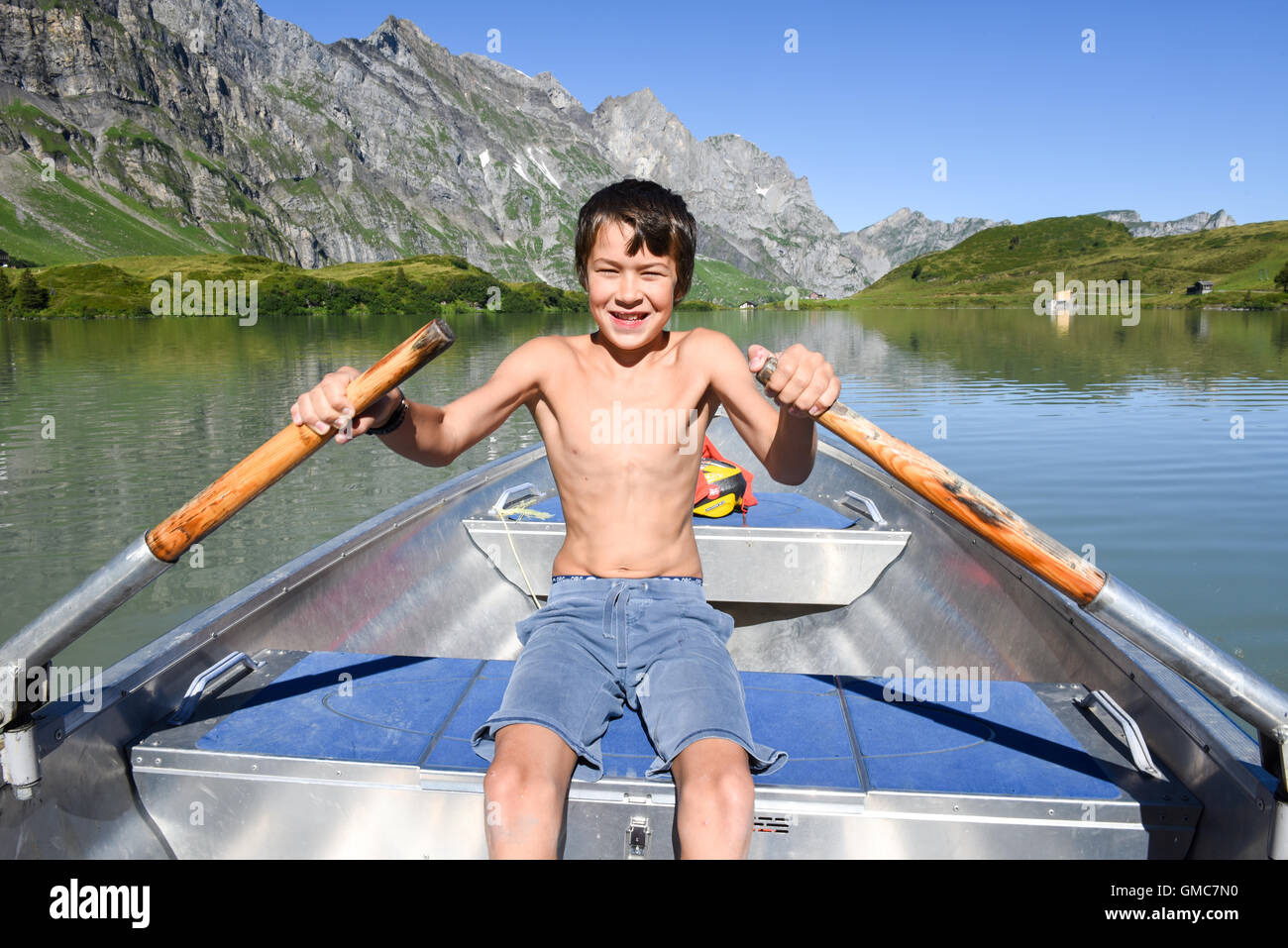 Engelberg, Switzerland - 8 august 2016: Boy rowing on Lake Truebsee ...