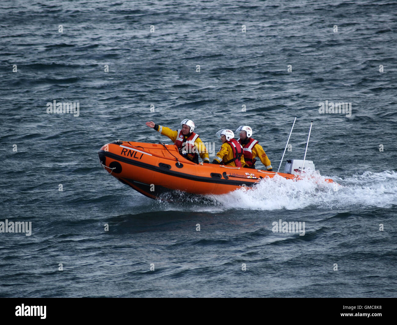 RNLI inshore RIB & three crew racing to a incident Stock Photo - Alamy