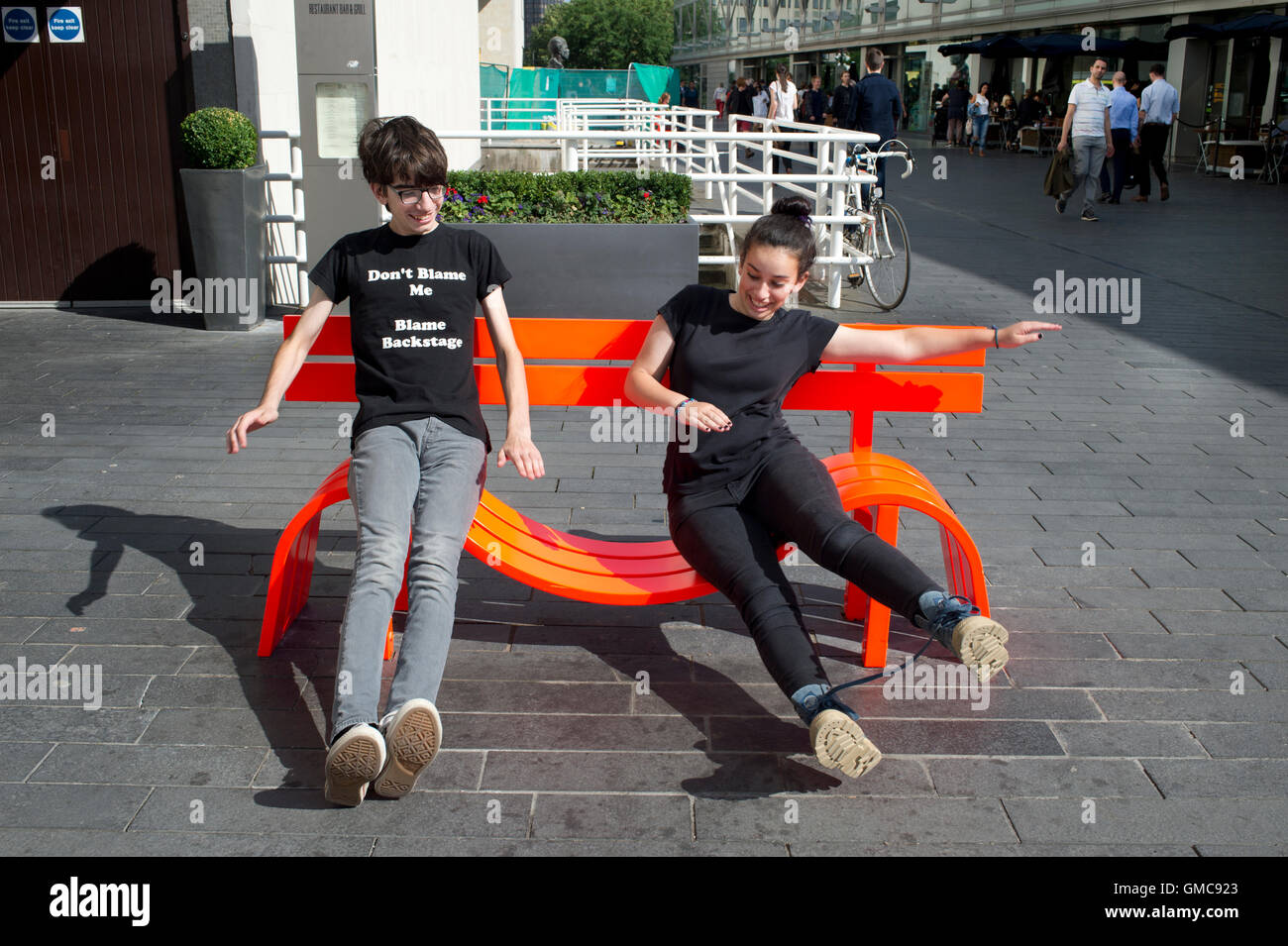 London.South Bank. Modified social bench NY. A young boy and girl play ...