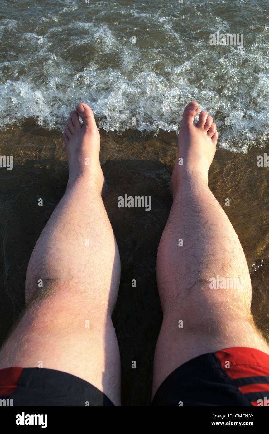 Symbol vacation at sea. Feet on the beach Stock Photo - Alamy