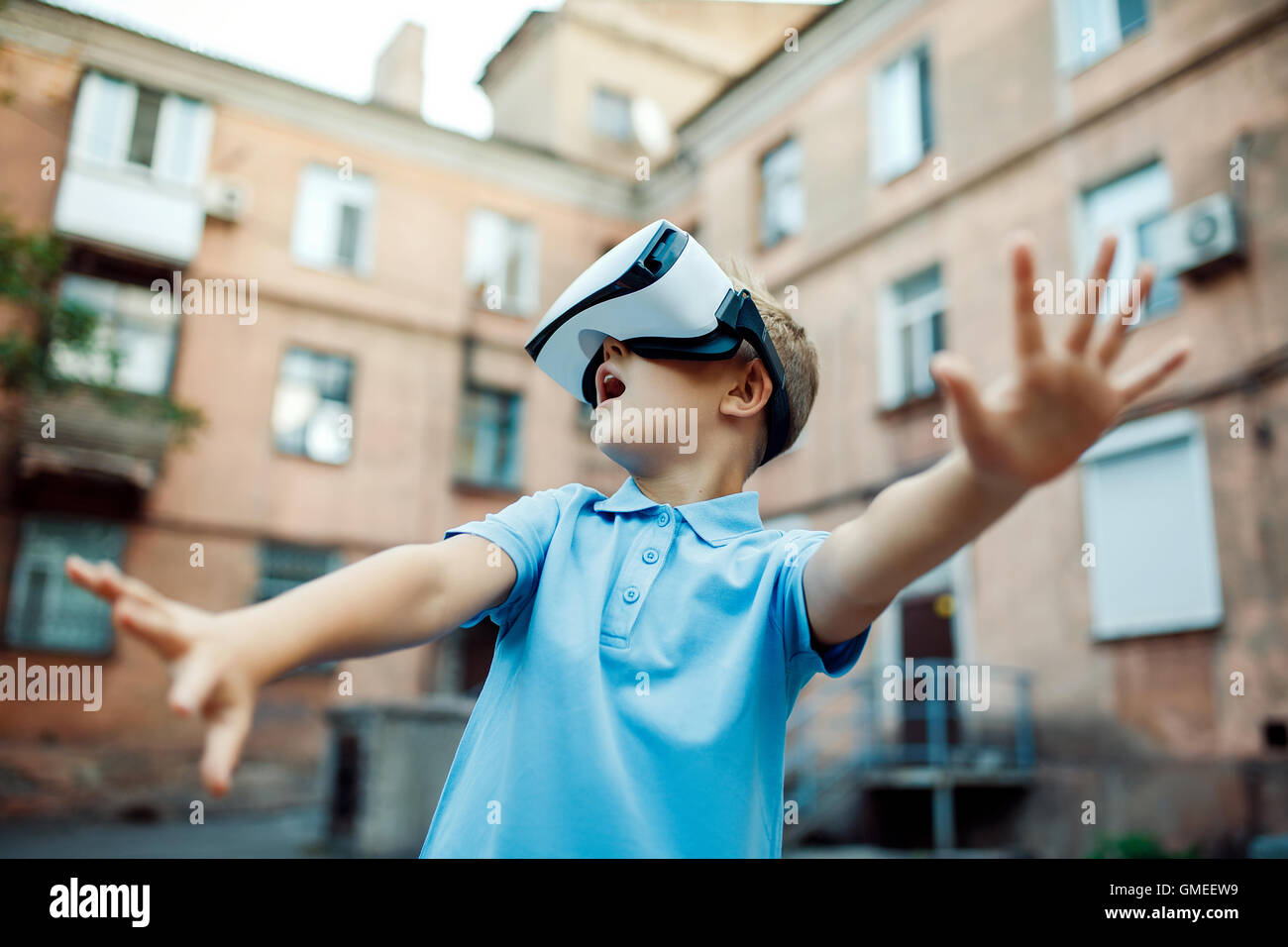 Fascinated little boy using VR virtual reality goggles. outdoor Stock ...