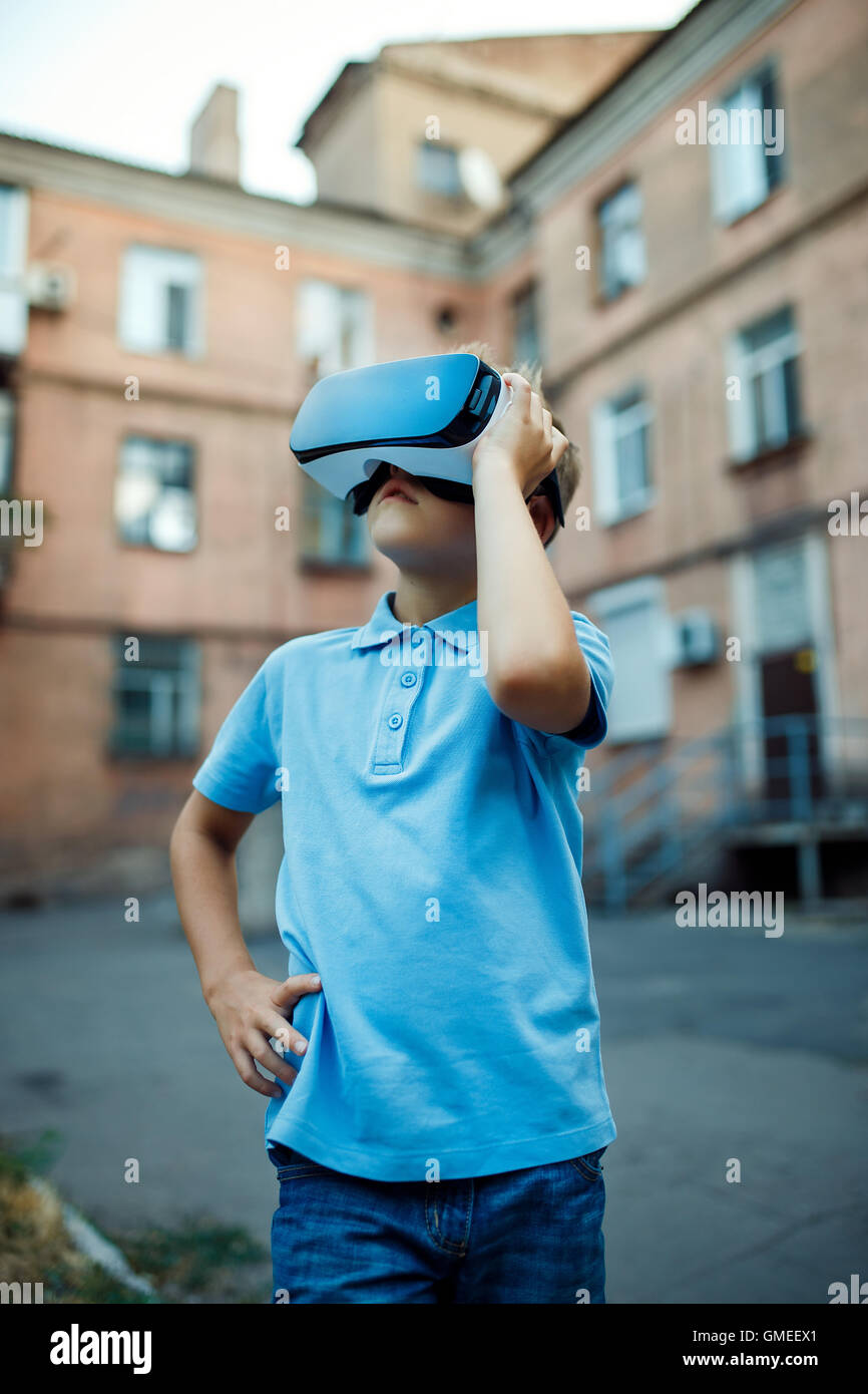 Fascinated little boy using VR virtual reality goggles. outdoor Stock ...