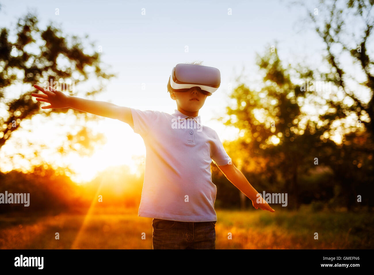 Fascinated little boy using VR virtual reality goggles. outdoor Stock ...