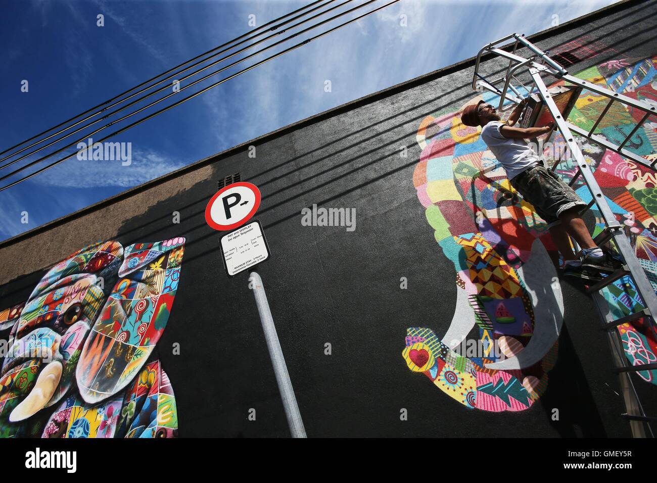UK artist Louis Masai works on a mural highlighting endangered species ...