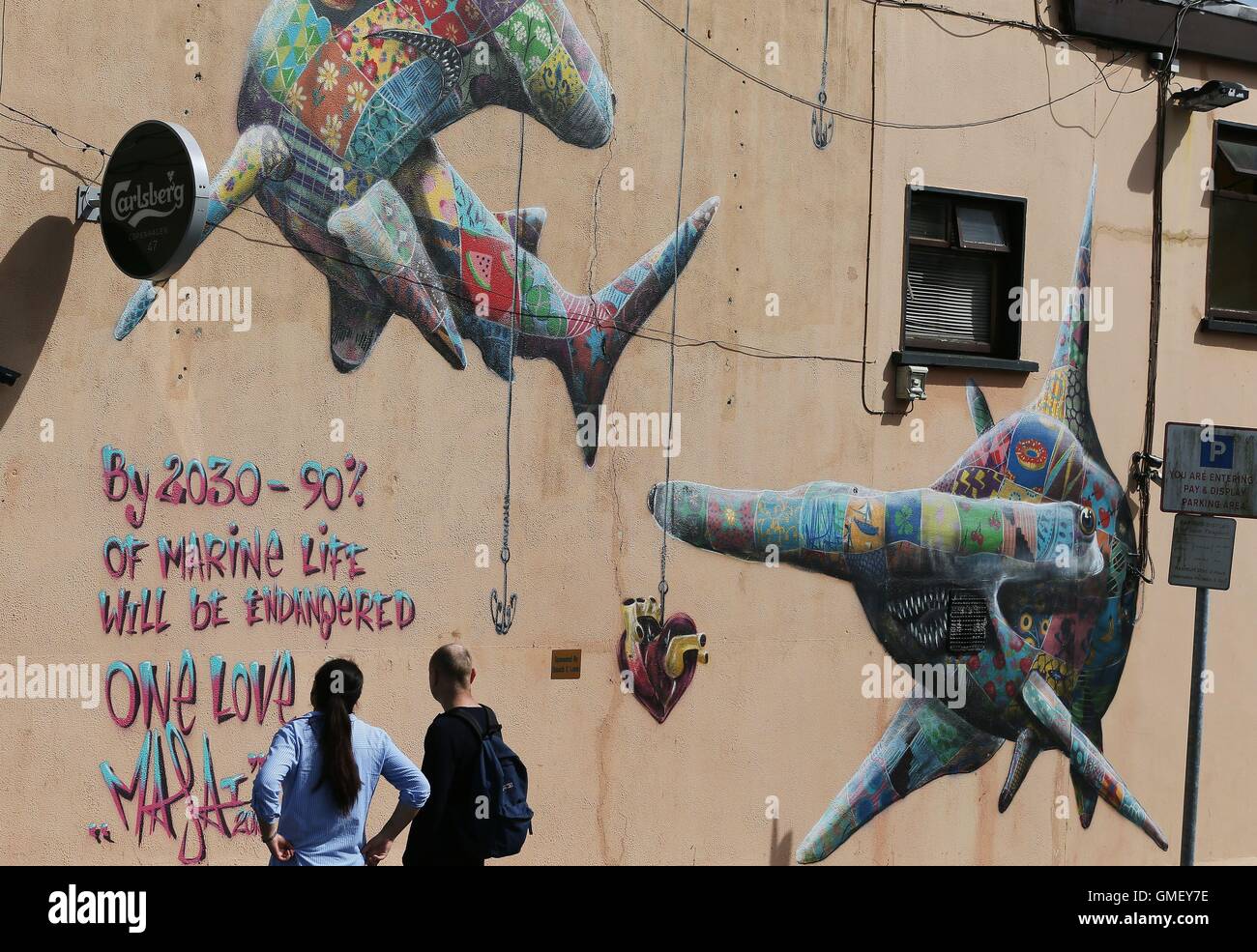 People observe a surviving mural by UK artist Louis Masai from last ...