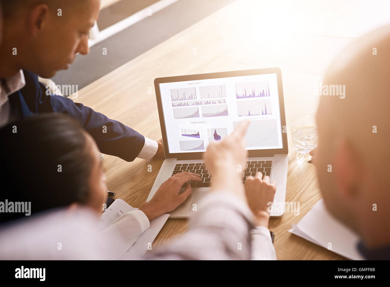 Group of business people looking at graphs on a laptop Stock Photo - Alamy